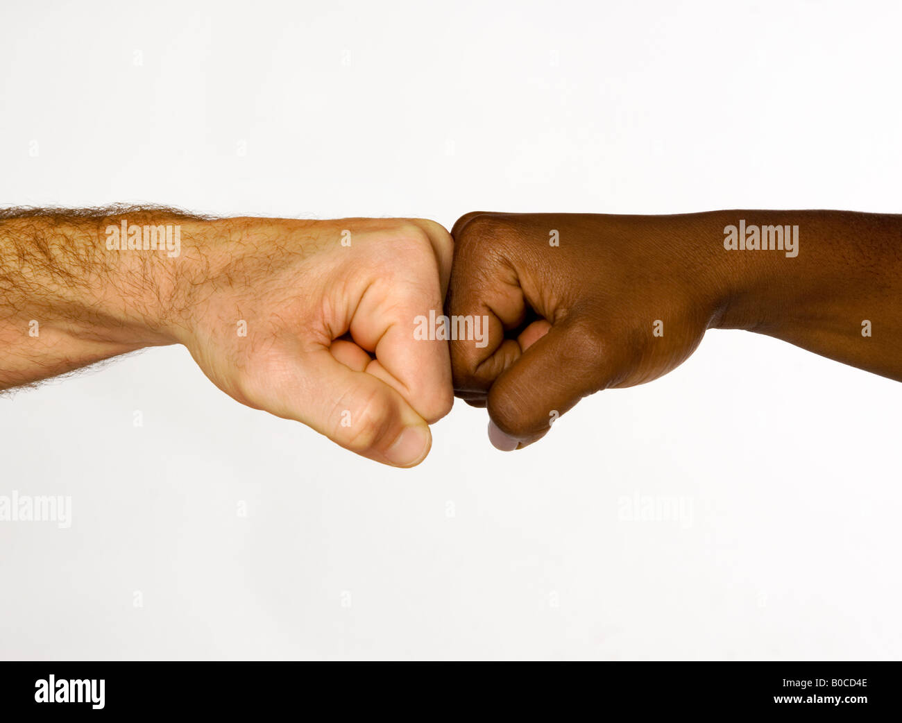 Two fists of different race colliding Stock Photo - Alamy
