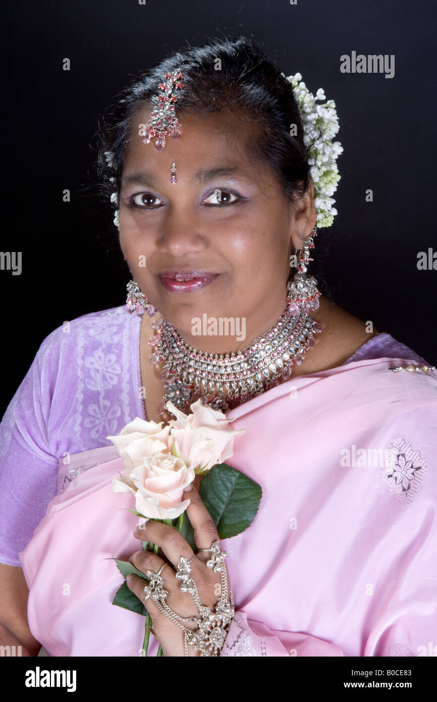 Happy Indian woman in saree holding soft pink roses Stock Photo - Alamy