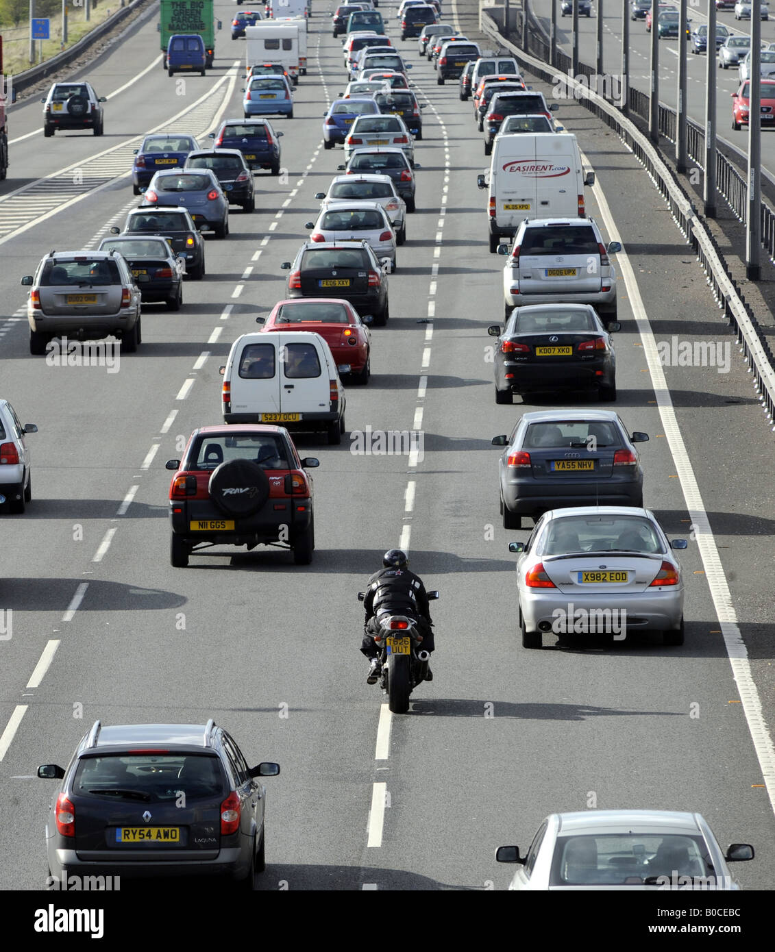 A MOTORCYCLIST FILTERS THROUGH TRAFFIC QUEUES ON THE M6 MOTORWAY ...