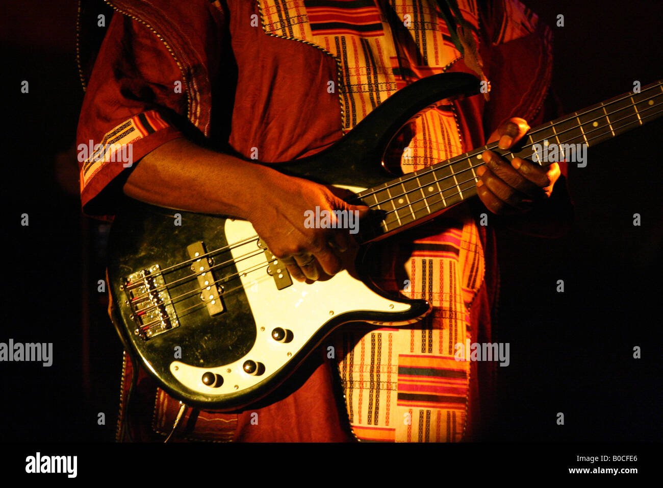 African musician in traditional dress plays the bass guitar Stock Photo ...