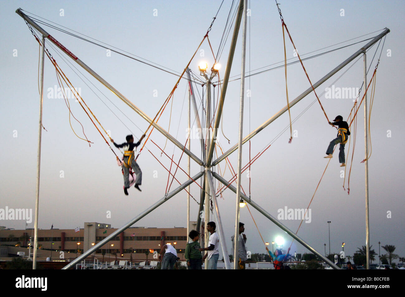 Kuwait play fun boys kids trampoline two wires Stock Photo - Alamy