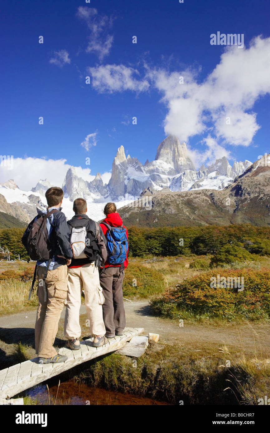 Three hikers on path looking at The Fitz Roy Range in Argentina ...