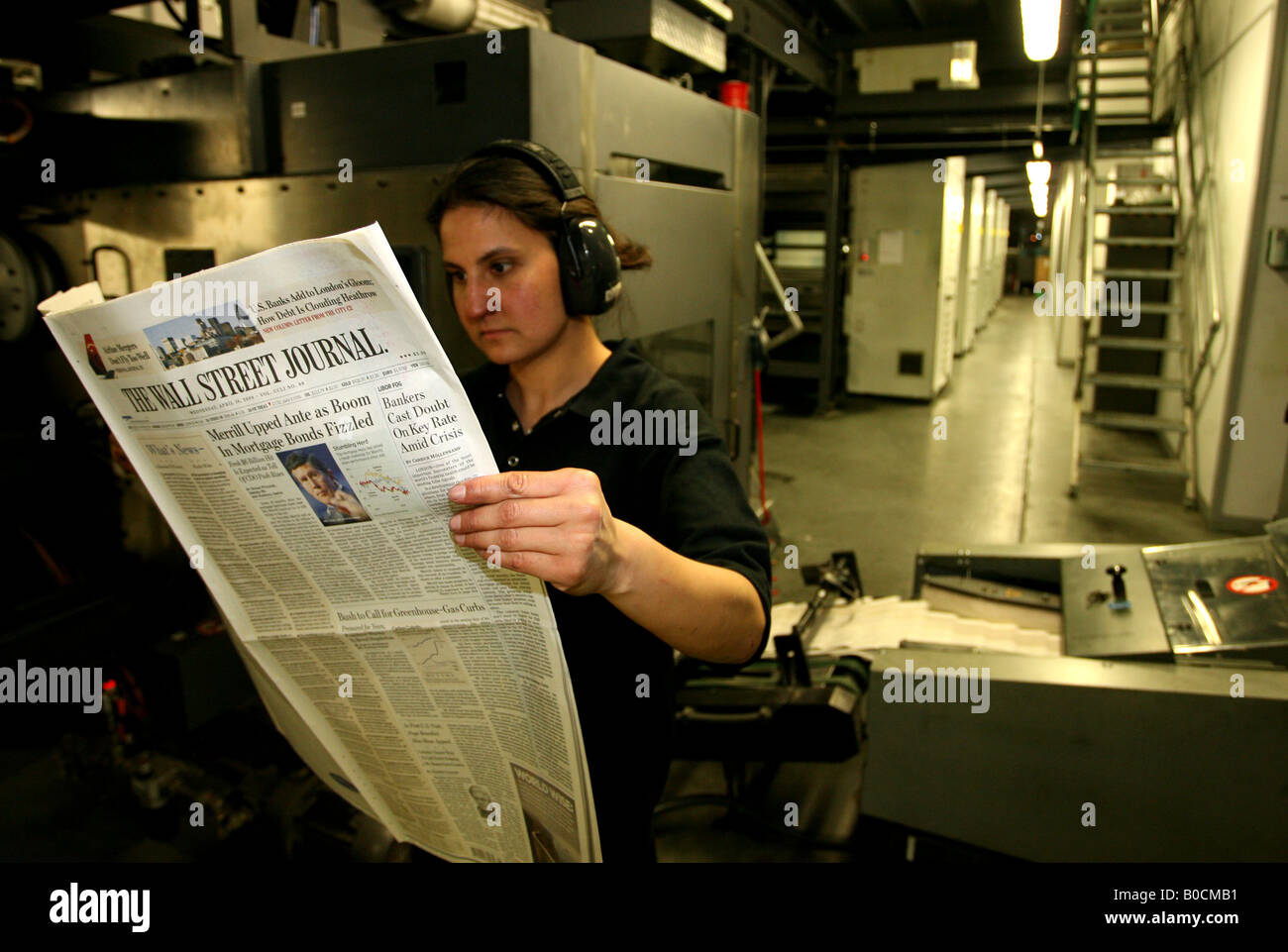 A worker checks copies of Wall Street Journal newspapers as they are ...
