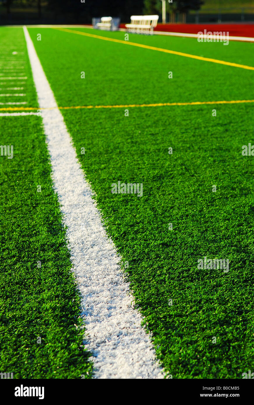 Green sports field with artificial grass and racetrack Stock Photo - Alamy
