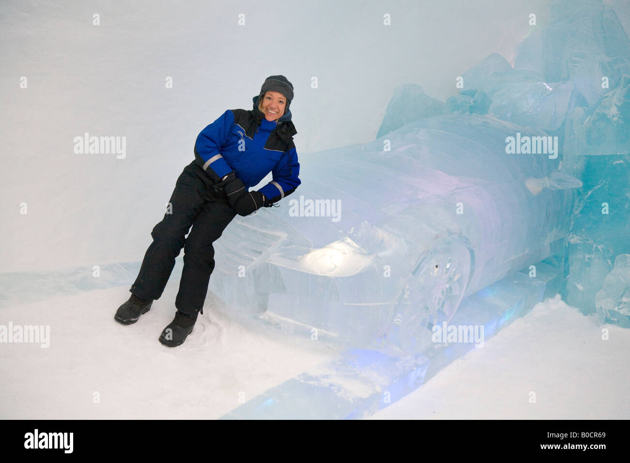 A woman leans against a car made of ice inside the Jukkasjarvi icehotel ...