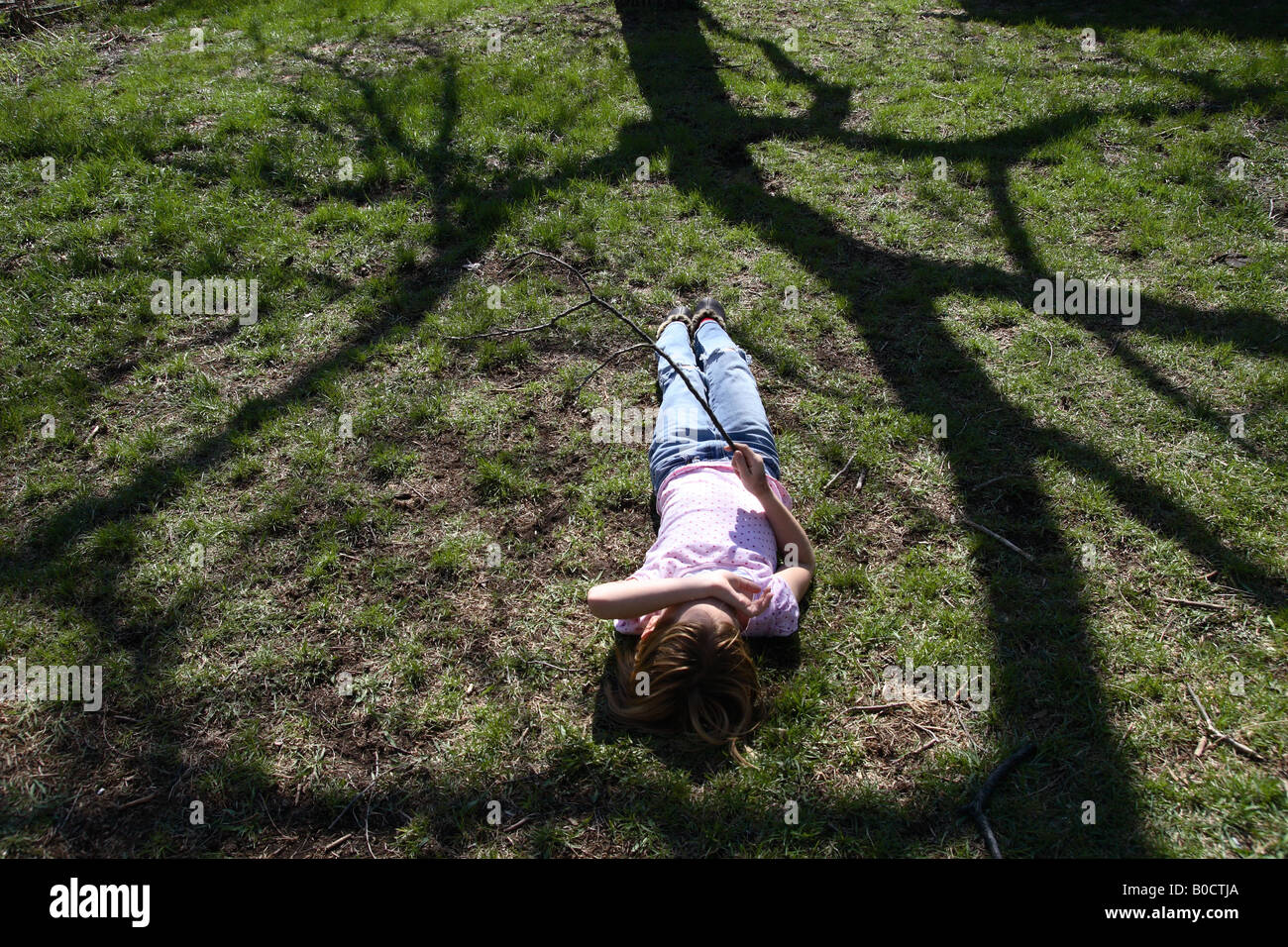 A young girl lying in the shadow of a tree Stock Photo - Alamy