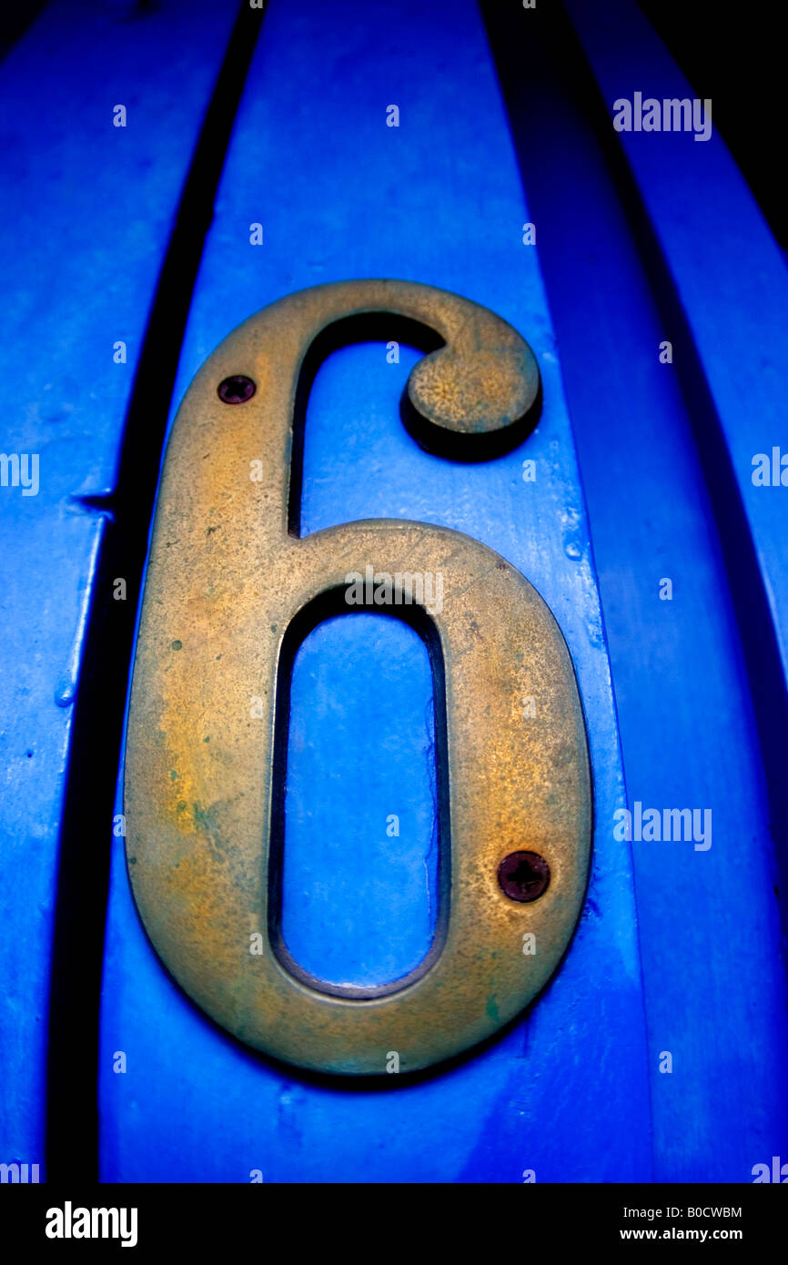 Large brass number 6 on blue wall Stock Photo - Alamy