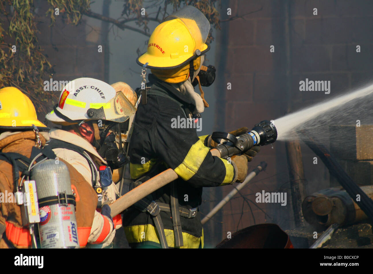 Firefighters fighting fire Stock Photo - Alamy