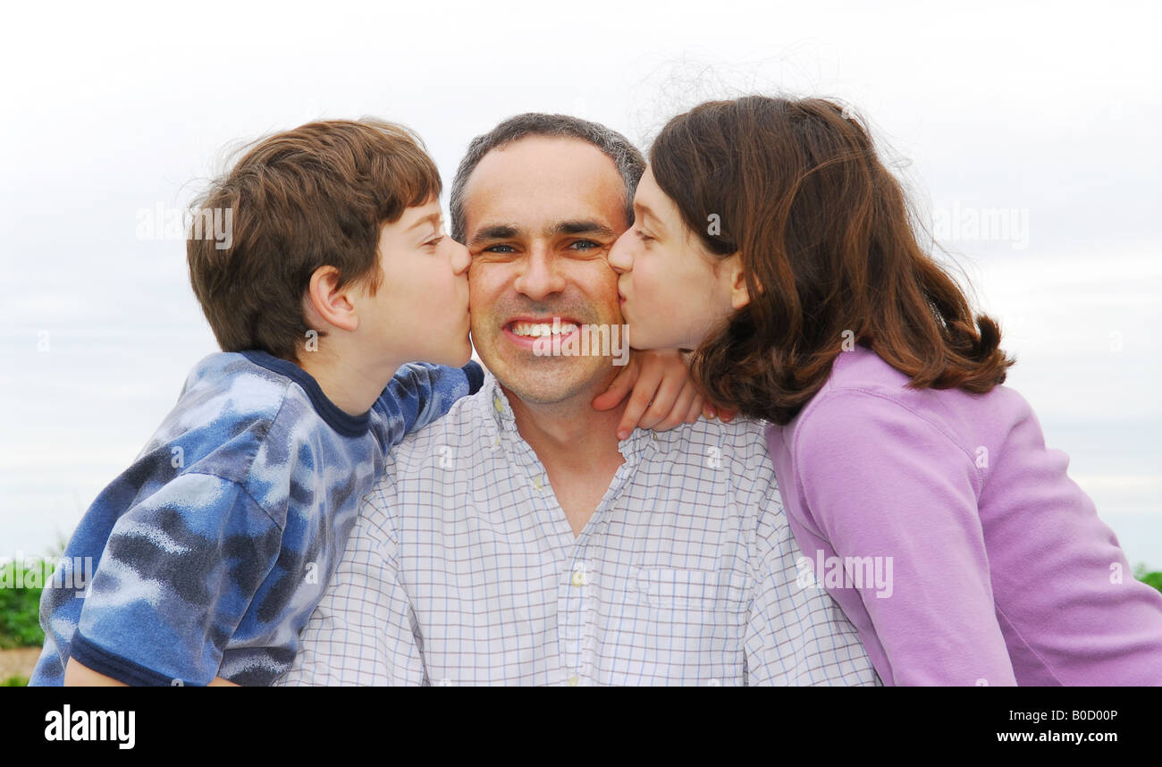 Grateful children giving their father a kiss Stock Photo - Alamy