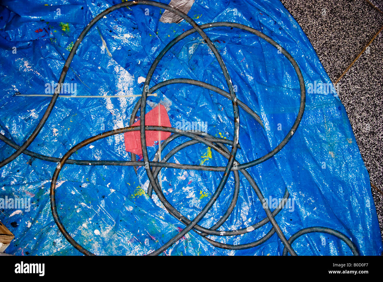 Electrical cable sitting on a paint covered tarpaulin Stock Photo - Alamy