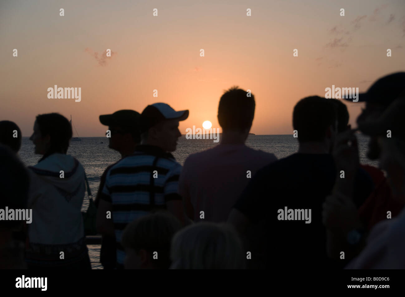 Tourists watching the sun set into the sea at the sunset ceremony in ...