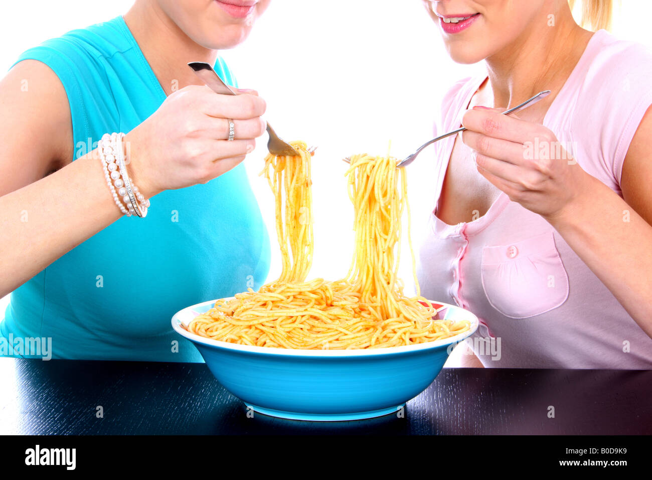 Two Girl Friends Sharing And Enjoying A Large Bowl Of Italian Spaghetti ...