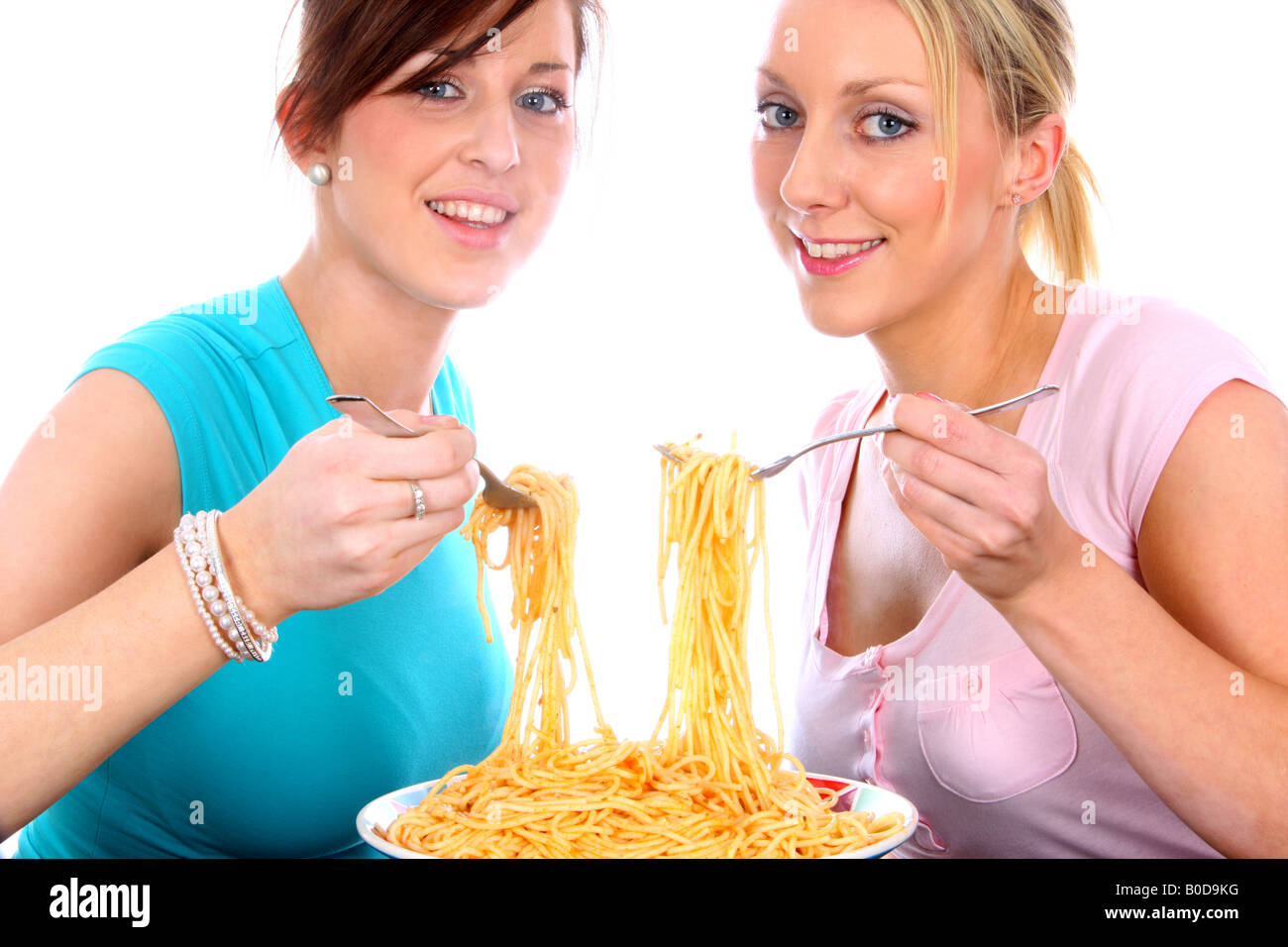 Two Girl Friends Sharing And Enjoying A Large Bowl Of Italian Spaghetti ...