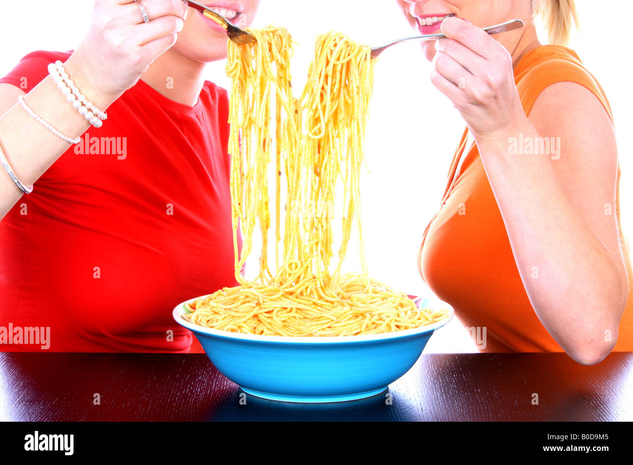 Two Girl Friends Sharing And Enjoying A Large Bowl Of Italian Spaghetti ...