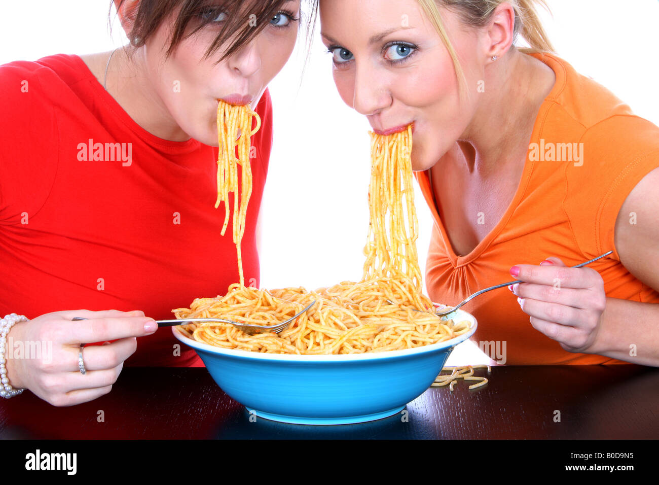 Two Girl Friends Sharing And Enjoying A Large Bowl Of Italian Spaghetti ...