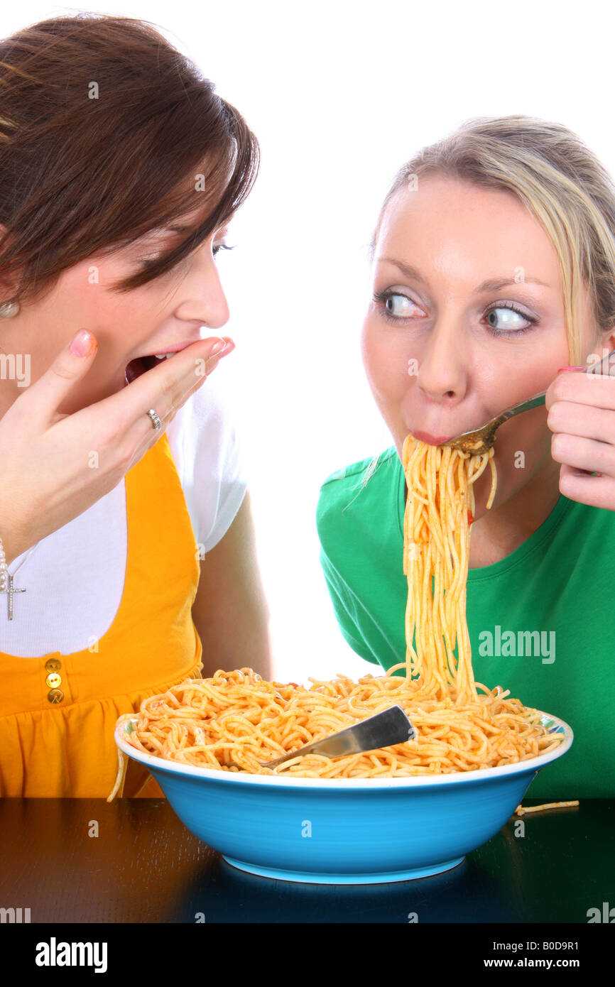Two Girl Friends Sharing And Enjoying A Large Bowl Of Italian Spaghetti ...