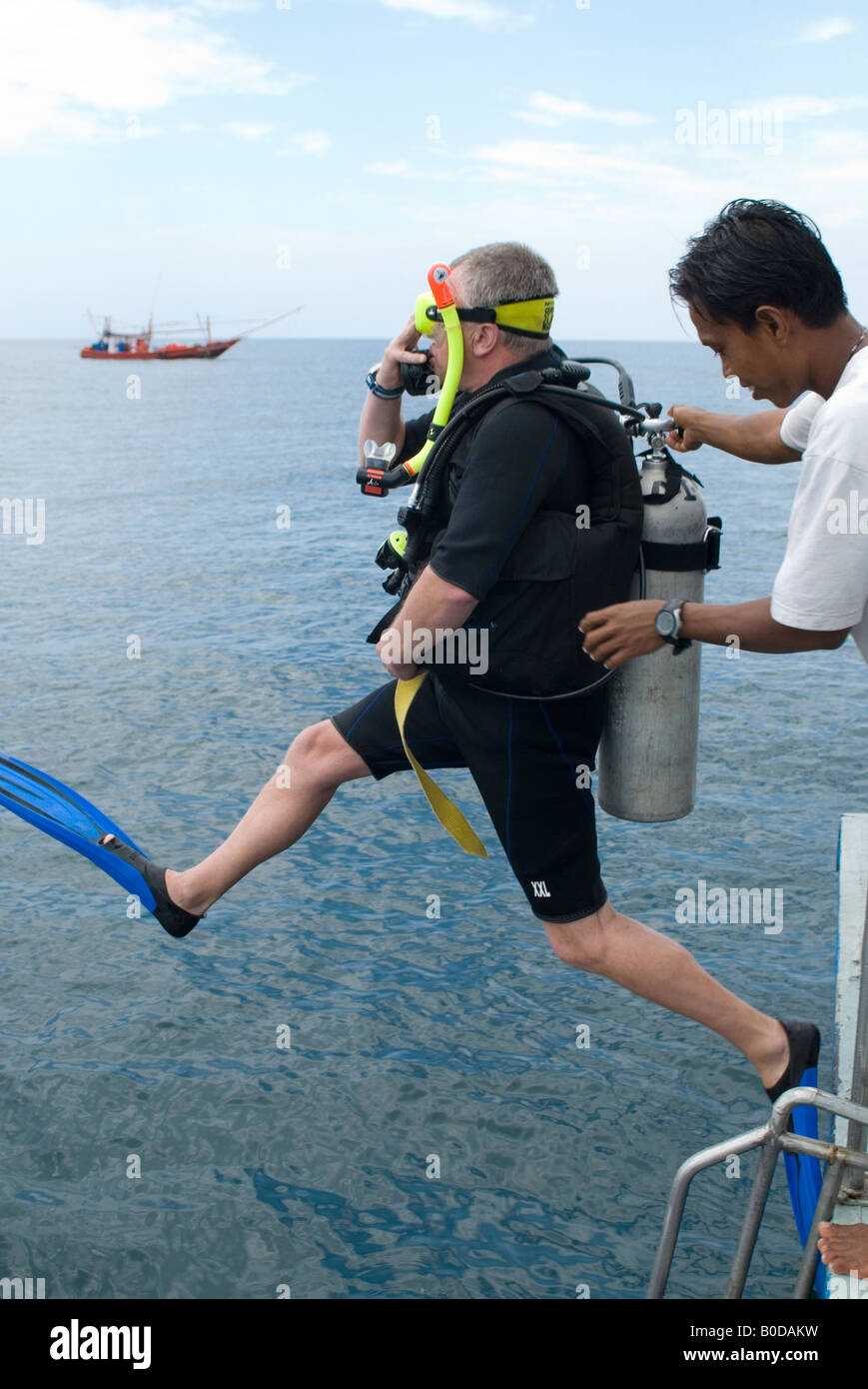 A Western man jumps off of the dive boat for his first scuba adventure ...