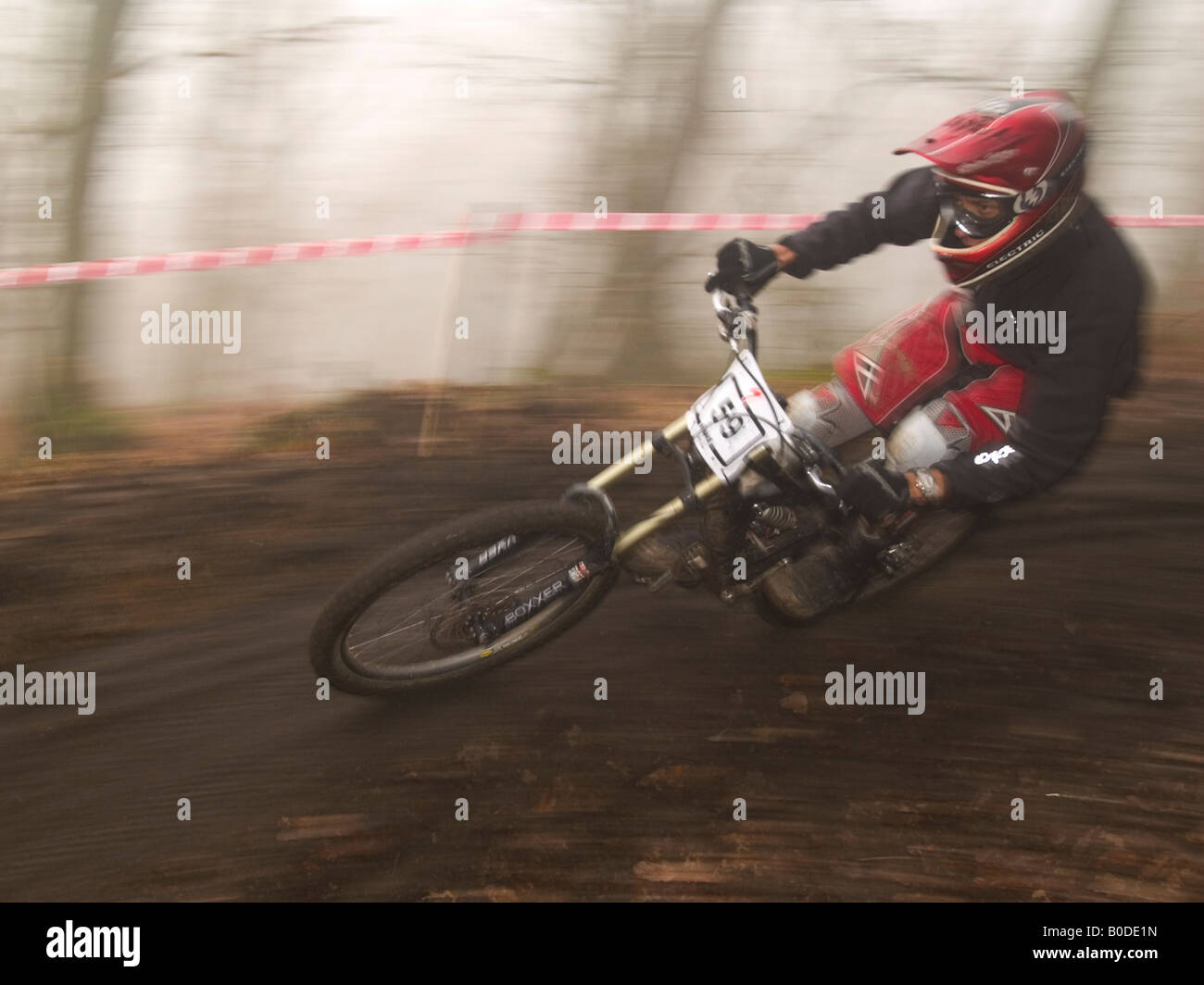 Mountain bike rider racing down a single track in a wooded area Stock ...