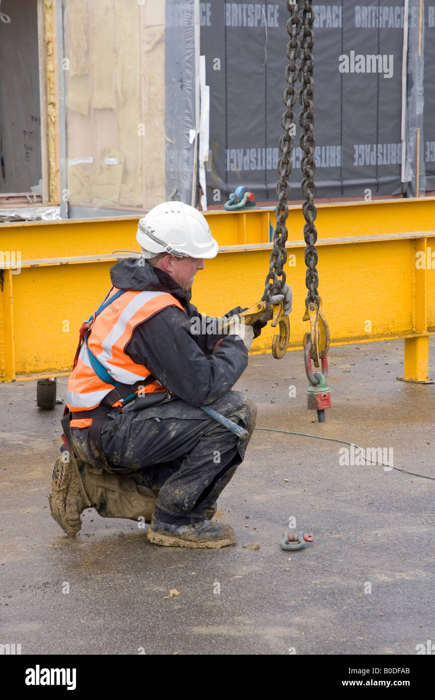 Construction worker adjusting crane chains Stock Photo - Alamy