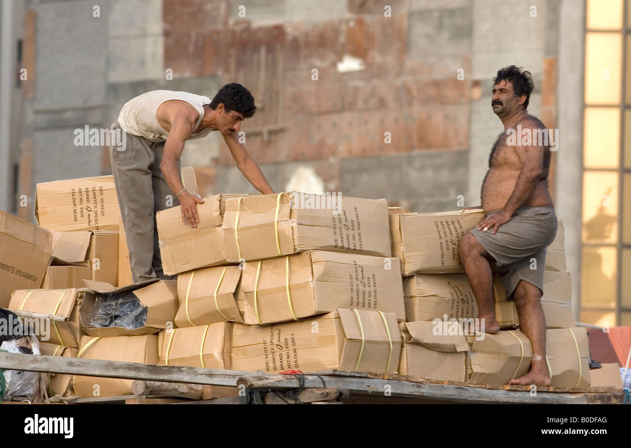 Men loading boxes of goods in the creek of Dubai Stock Photo - Alamy