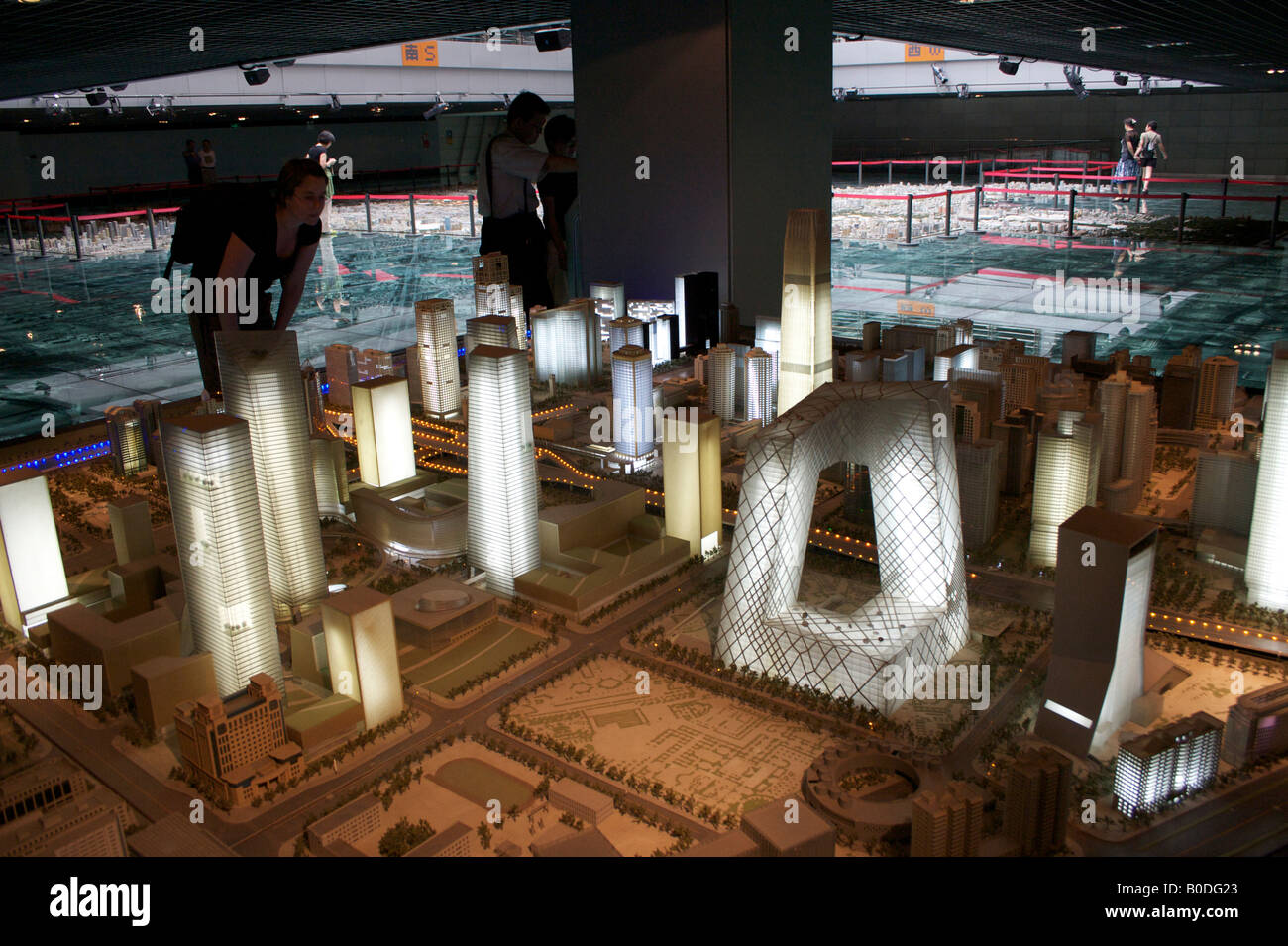 A tourist looks at illuminated models of skyscrapers from Beijing s CBD ...