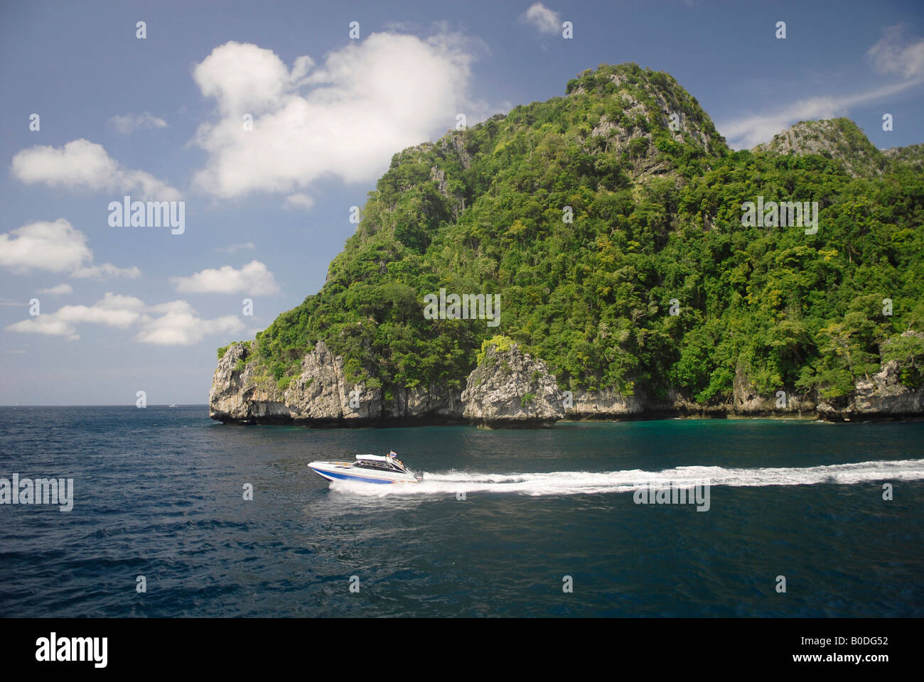 Speed boat passing a tropical island in Thailand Stock Photo - Alamy