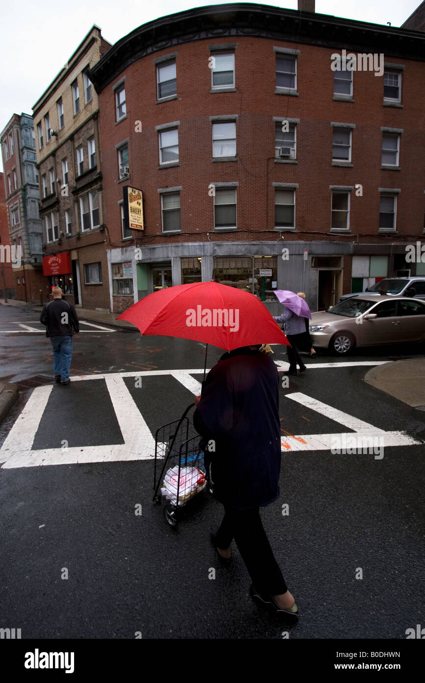 Pedestrians walk along the narrow streets of Boston s North End on a ...