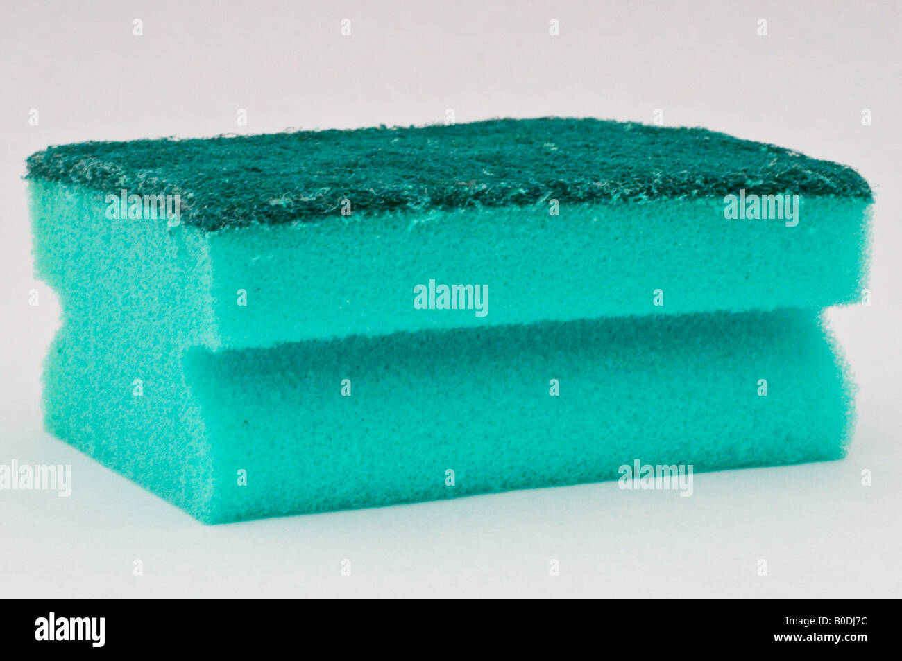 Shaped green washing up sponge with scourer View from the side. Close ...