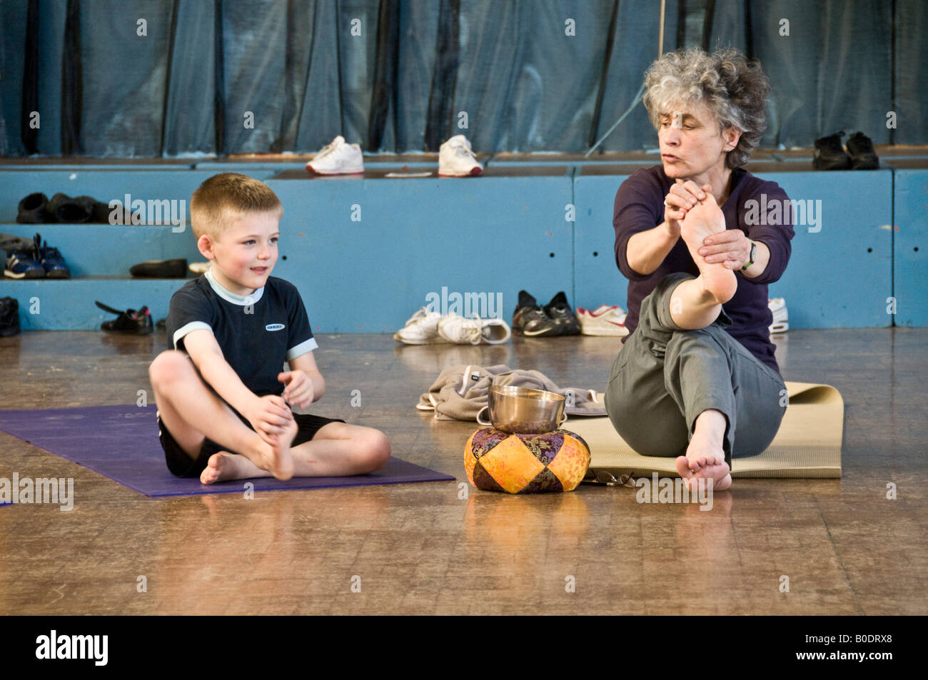 woman teaching a yoga relaxation class for primary school children ...
