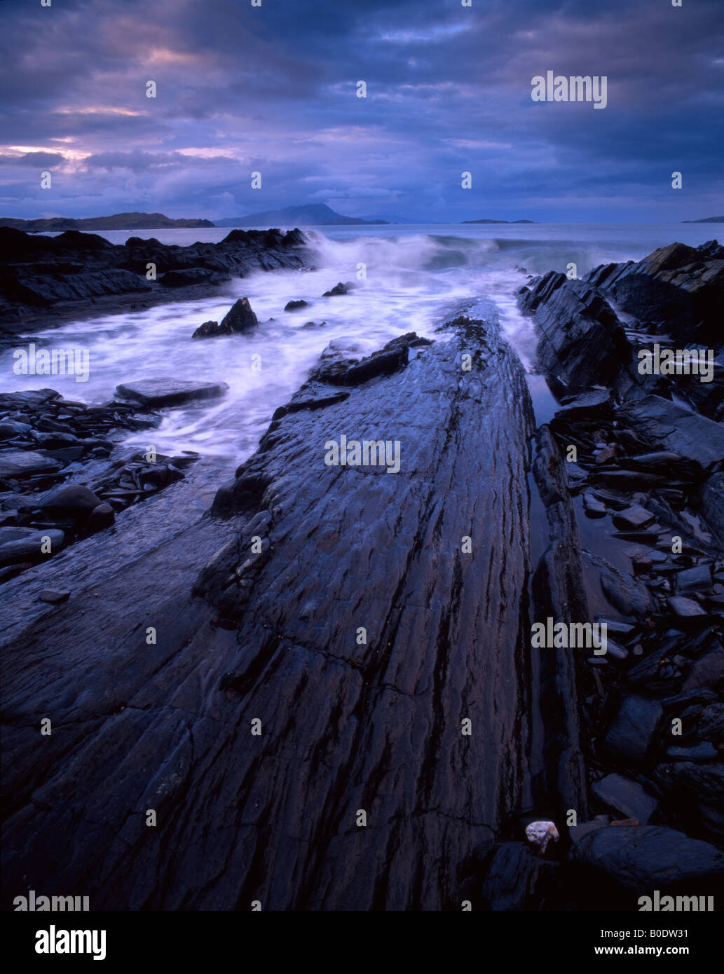 Incoming tide and dark skies on Seil with Scarba and Jura beyond ...