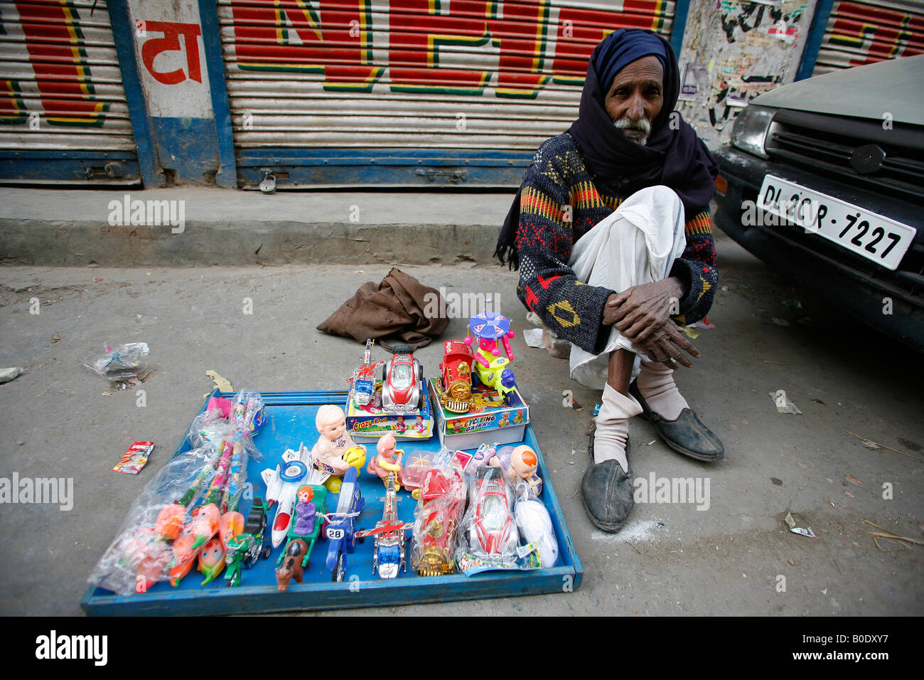 street vendor sitting on roadside selling his toys Stock Photo - Alamy