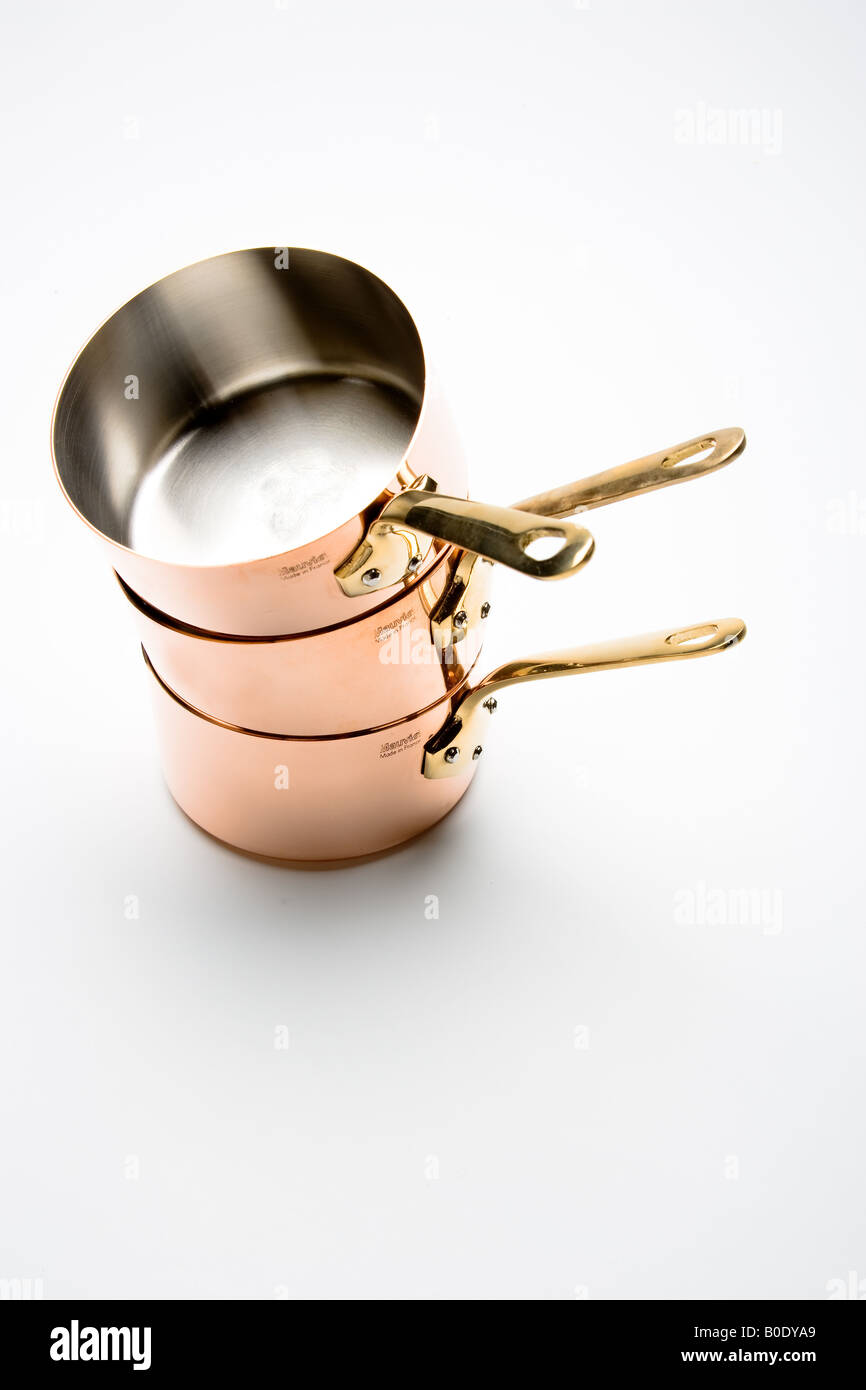 A stack of copper pots on a white background Stock Photo - Alamy