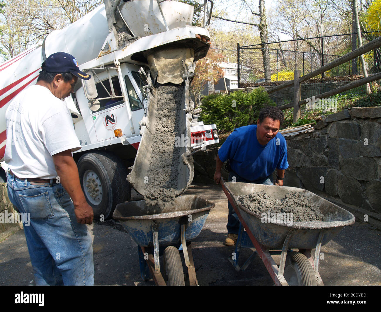 Day laborers taking concrete from truck Stock Photo - Alamy