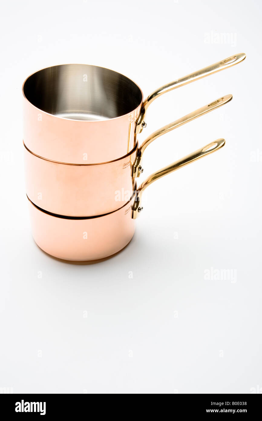 A stack of copper pots on a white background Stock Photo - Alamy