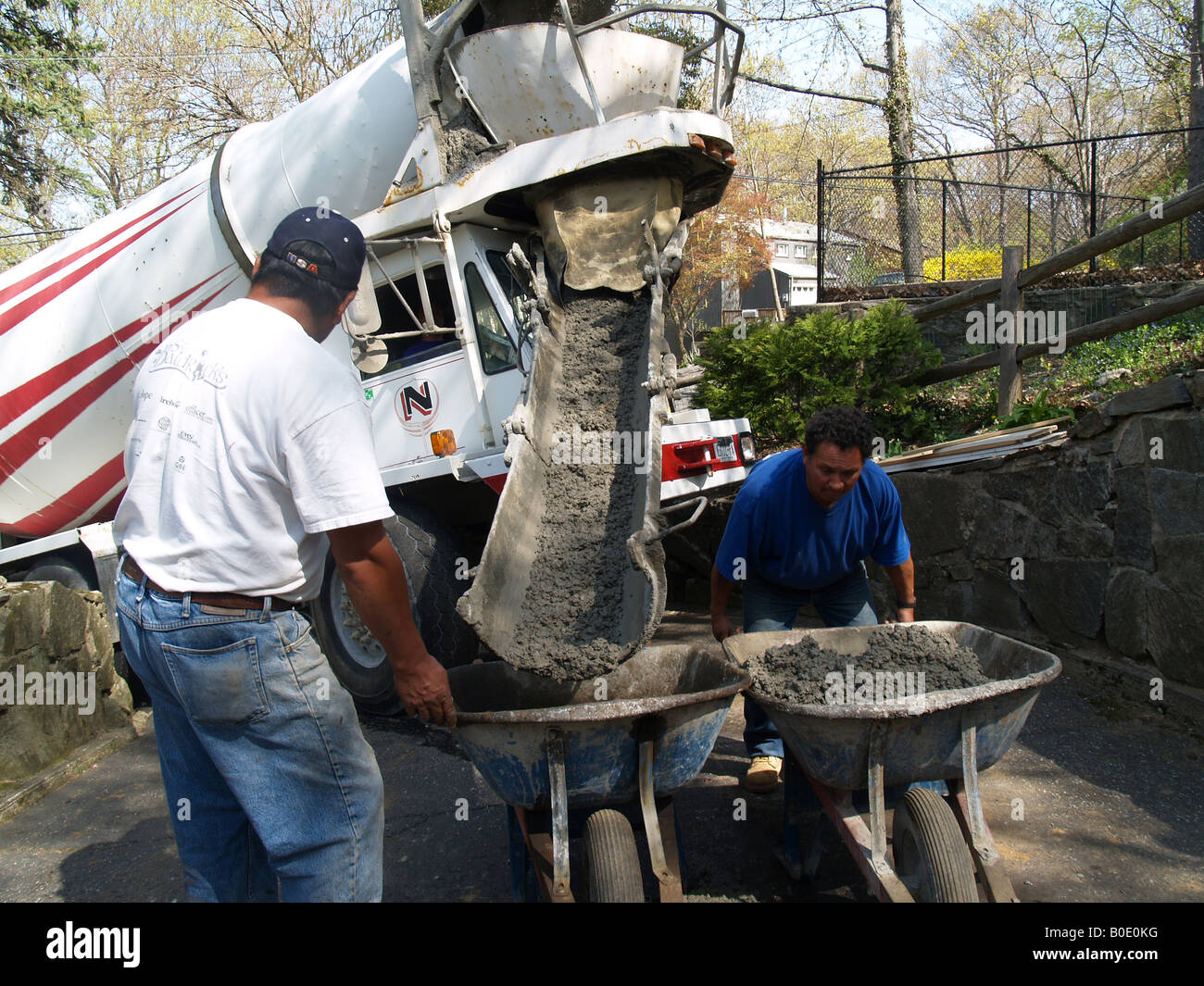 Day laborers taking concrete from truck Stock Photo - Alamy