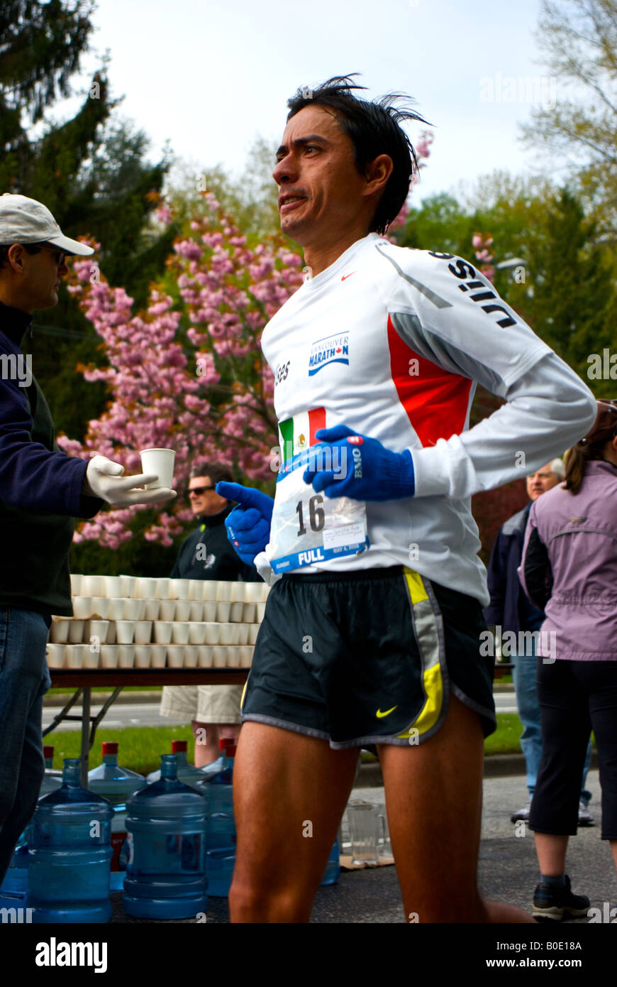 Volunteers handing out bottled spring water to runners at water station ...