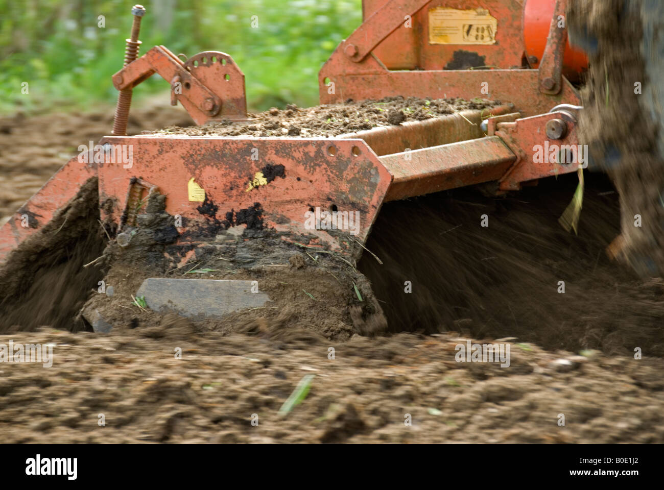 Stock photo of a tractor rotavating the soil to produce a fine tilth ...