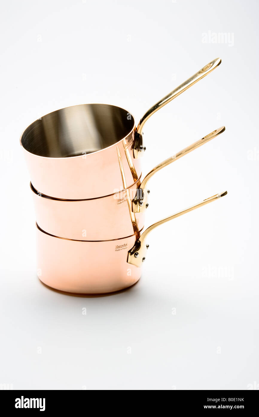 A stack of copper pots on a white background Stock Photo - Alamy