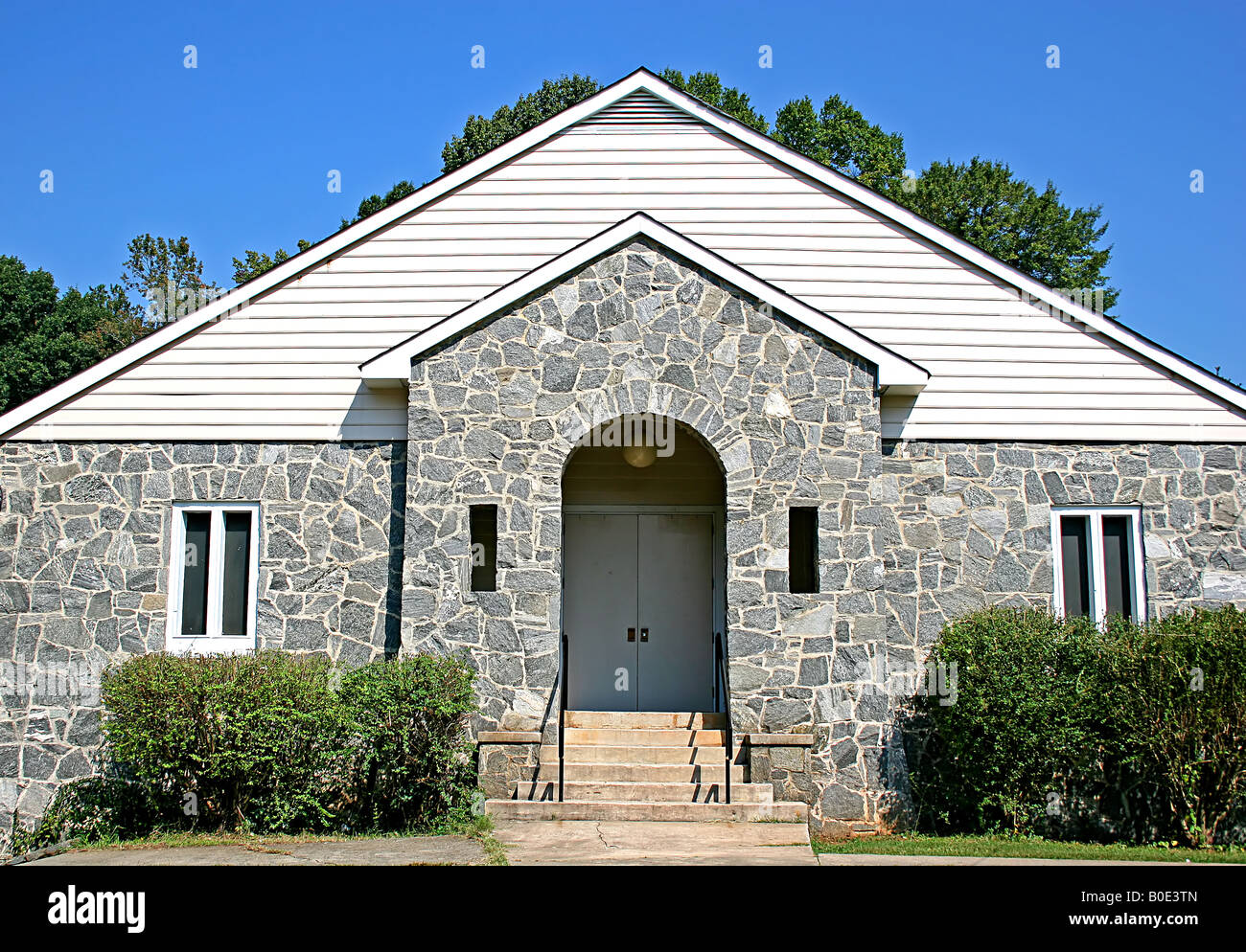 A Grey stone building against blue sky Stock Photo - Alamy