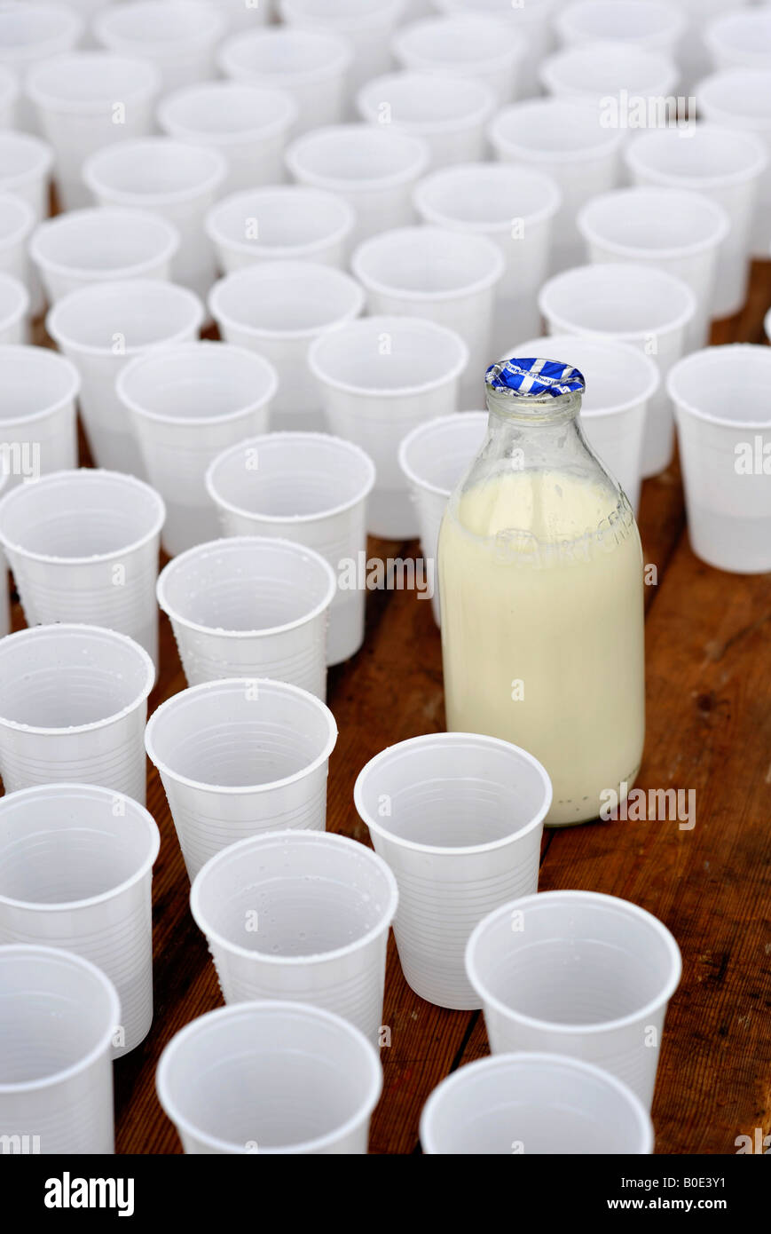 opened bottle of milk with plastic cups Stock Photo - Alamy