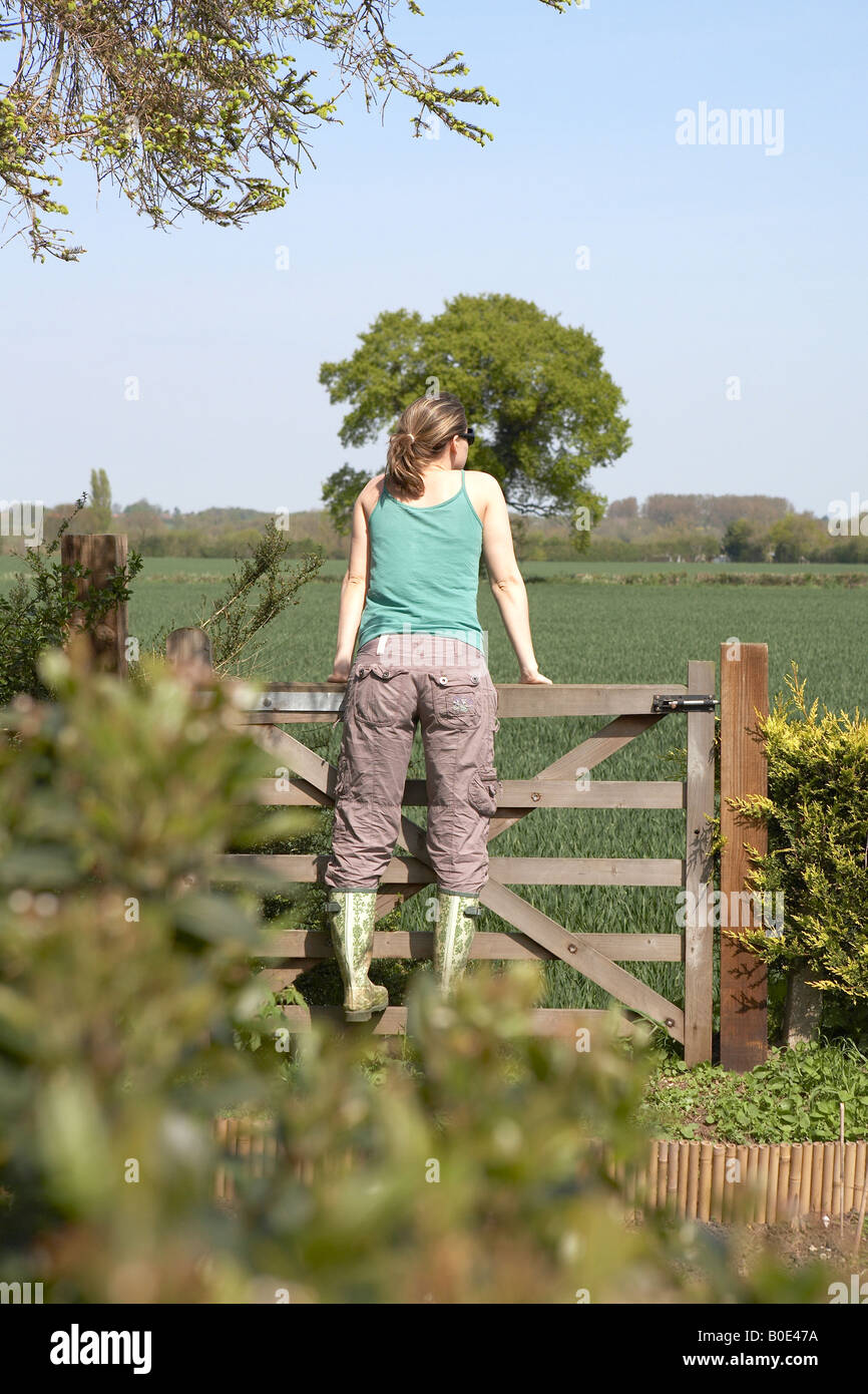 Young woman climbing on gate, rear view Stock Photo - Alamy