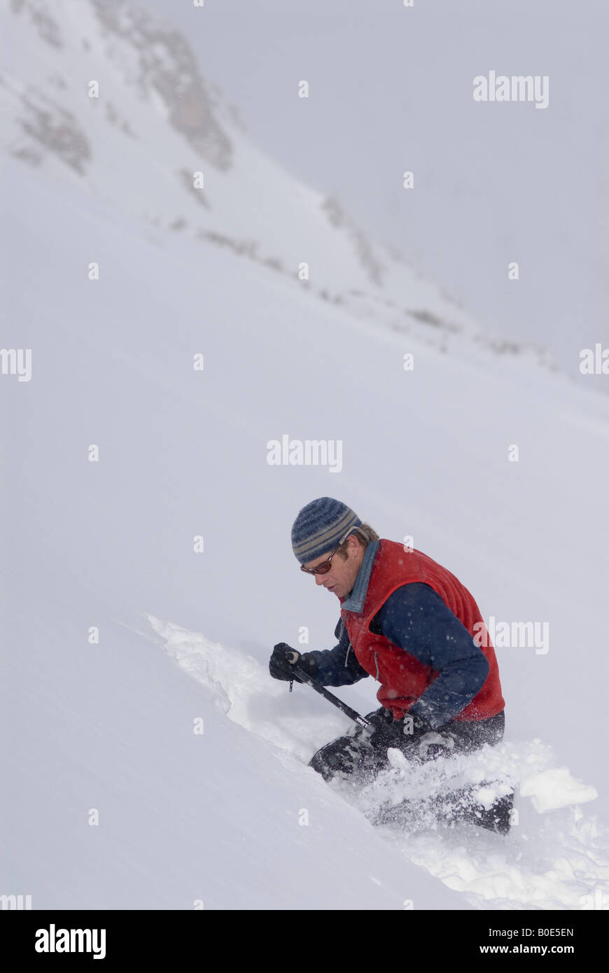 backcountry skier digging an avalanche pit in the snow- testing the ...