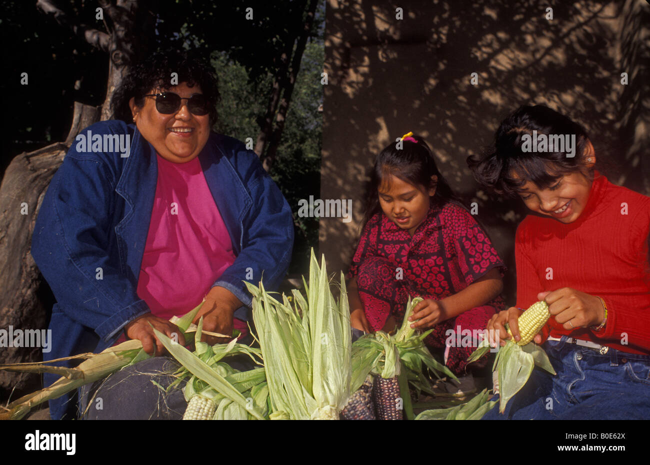 Native Americans shucking corn - Taos Pueblo New Mexico USA Mother and ...