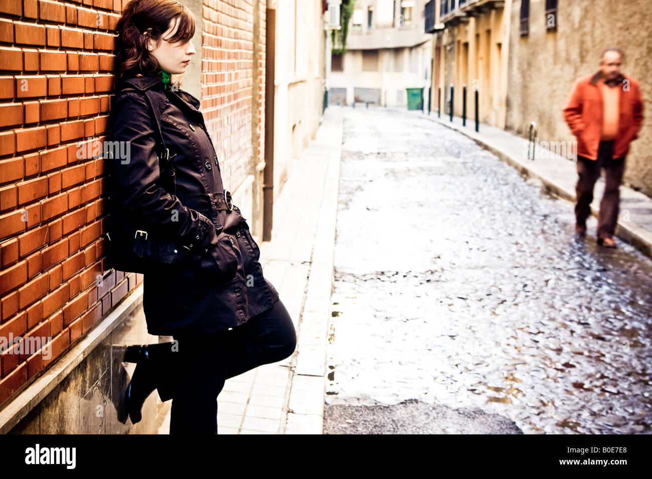 Woman on wall in urban background Stock Photo - Alamy