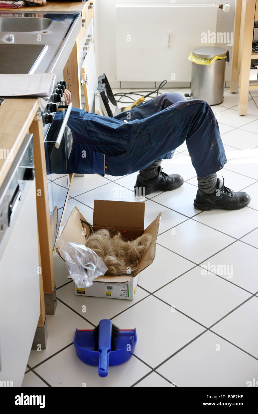 Plumber at work in a kitchen, inside a kitchen cabinet Stock Photo - Alamy
