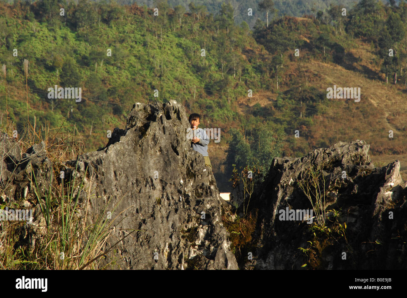 sin chai, boy hiding behind rock Stock Photo - Alamy
