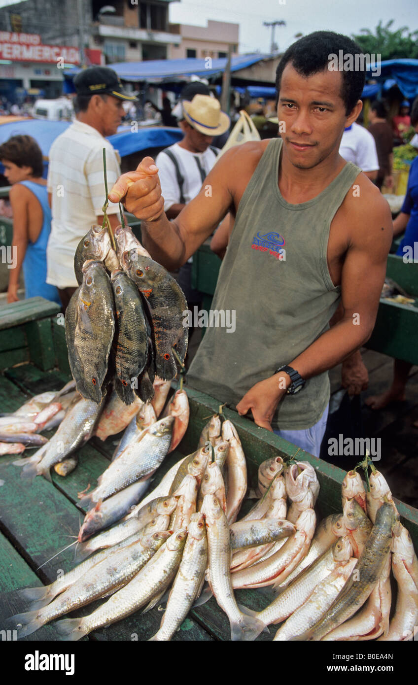 man holding up fish caught from the River Amazon in a fishmarket in ...