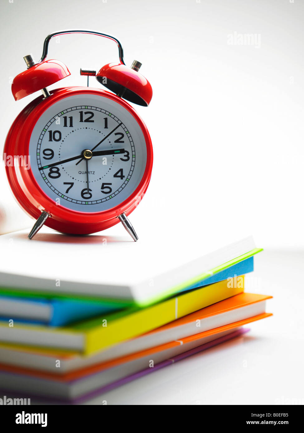 Close up view of alarm clock on pile of books Stock Photo - Alamy