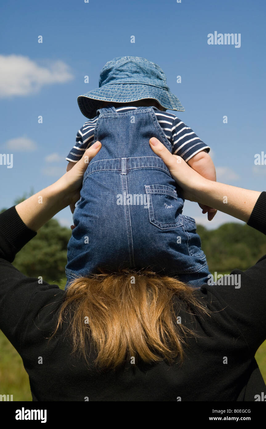 Mother carrying her baby on her shoulders Stock Photo - Alamy