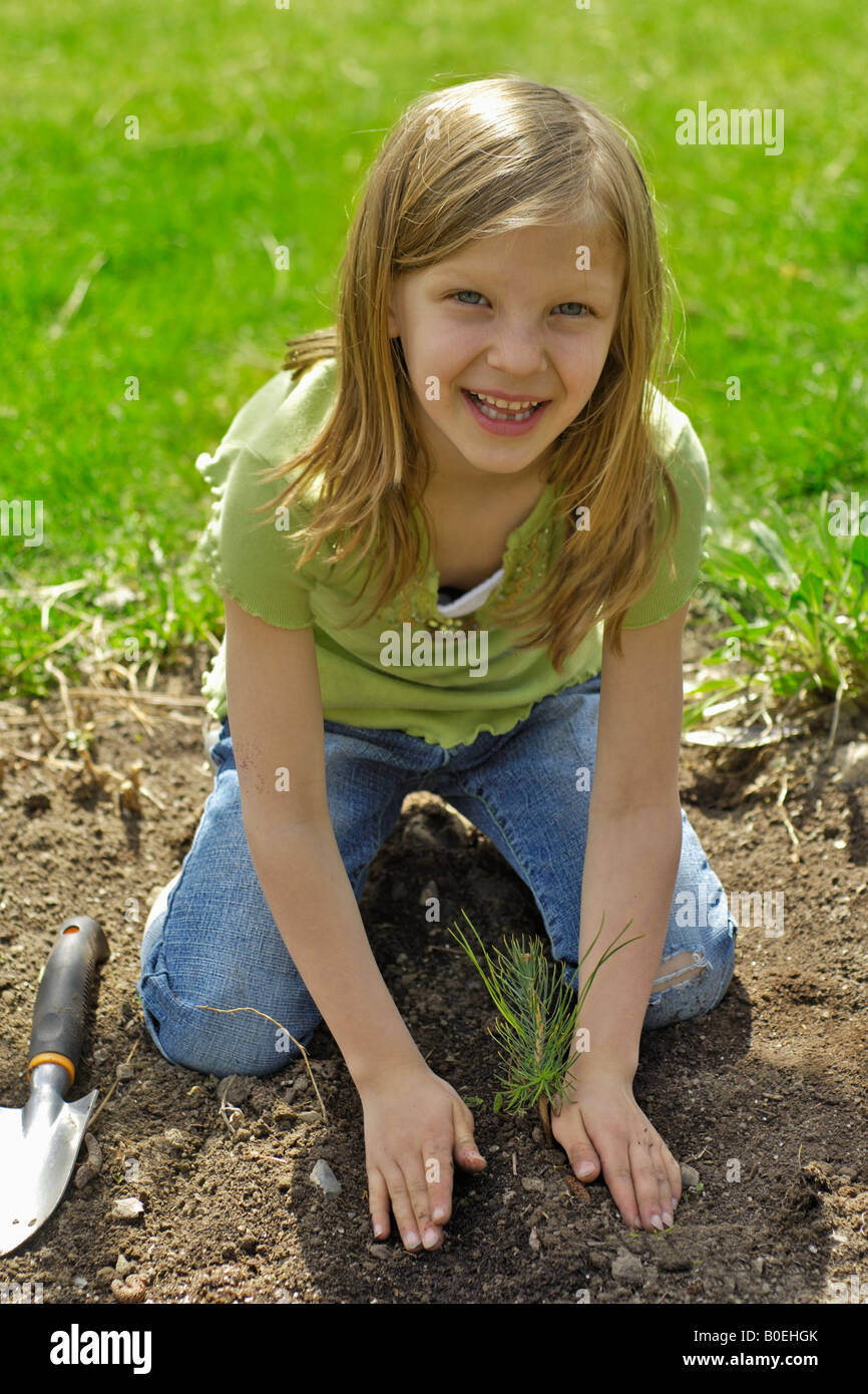 young girl planting a pine tree Stock Photo - Alamy